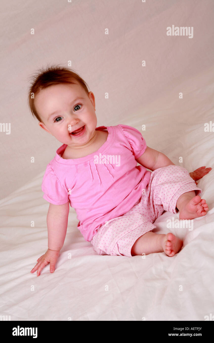 Gorgeous cute newborn baby at seven 7 months sitting up smiling and ...