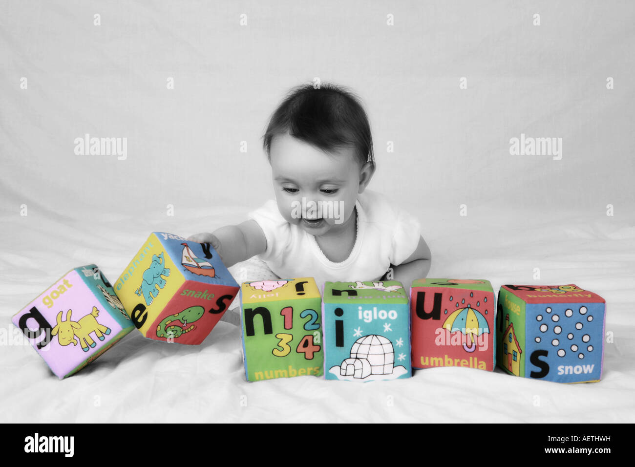 Cute newborn baby infant spells out word GENIUS from toy letter ...