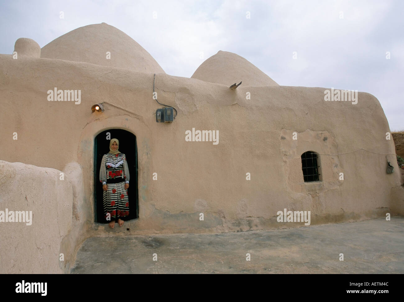 Woman in doorway of a 200 year old beehive house in the desert Ebla ...