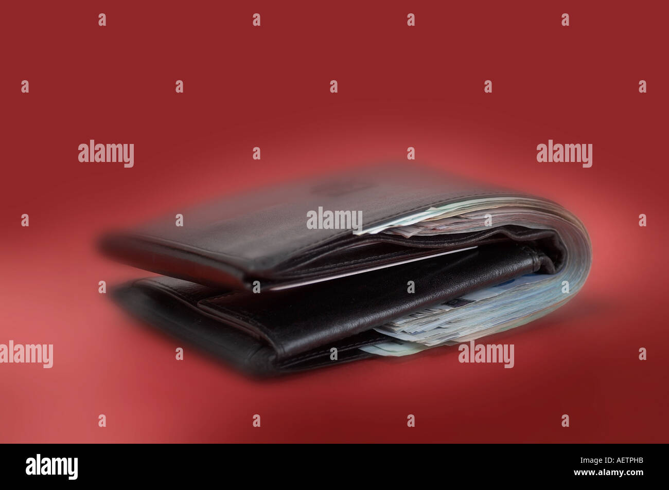 Wallet with stack of banknotes, in red background Stock Photo - Alamy