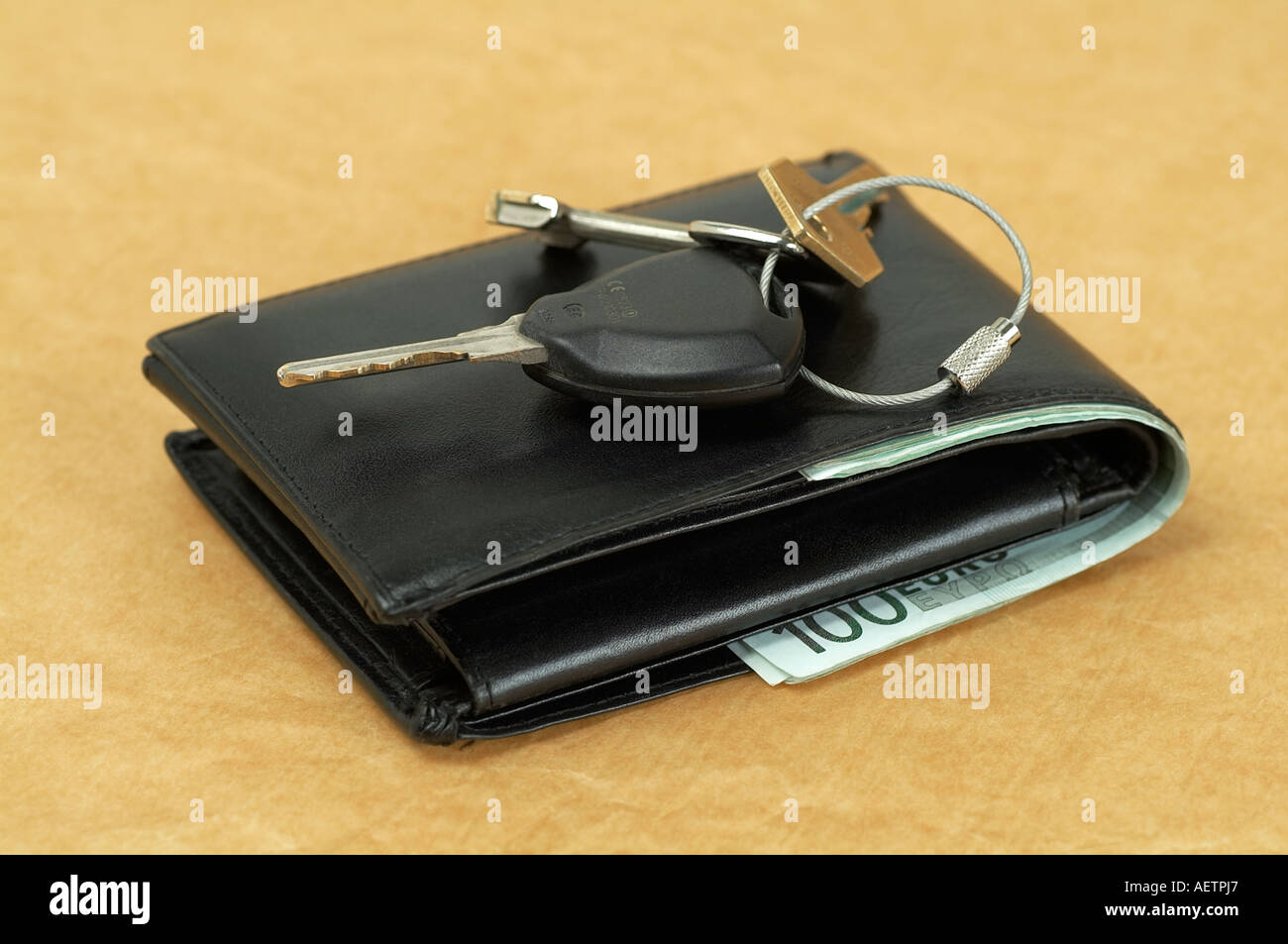 Wallet with banknotes of hundred euros and key ring with keys on yellow ...