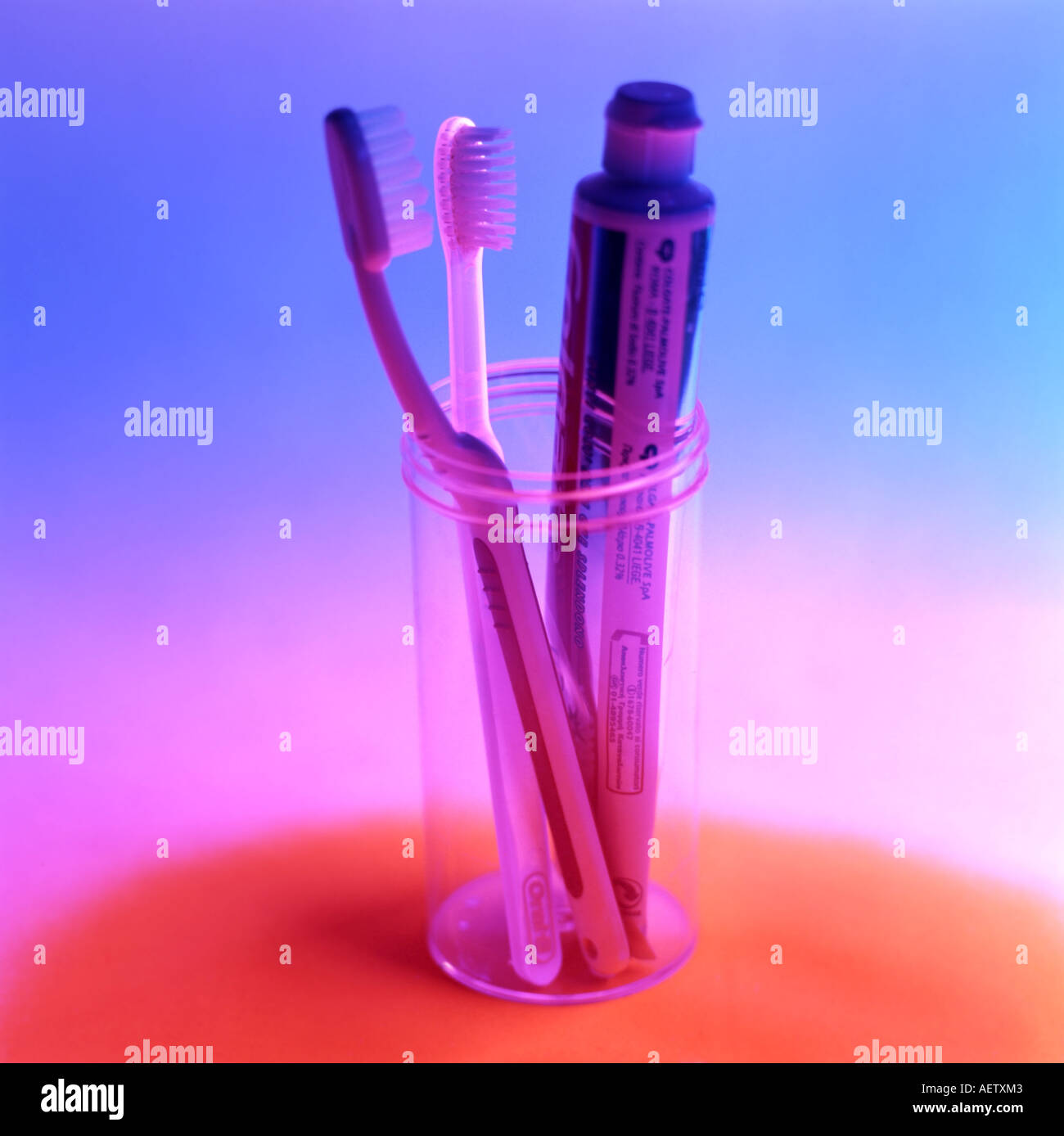 Toothbrushes and toothpaste in a plastic glass Stock Photo - Alamy