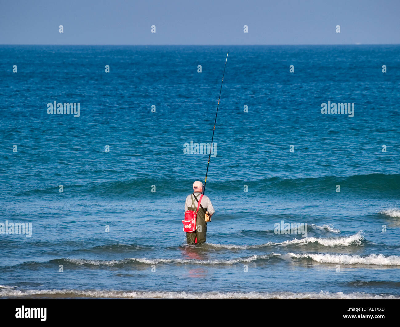 Sea angler fishing from the beach Stock Photo - Alamy