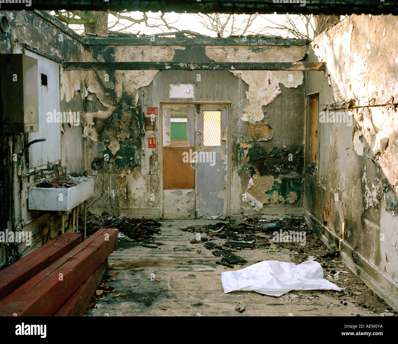 A changing room that has been damaged by fire. Peeling paint work. No ...