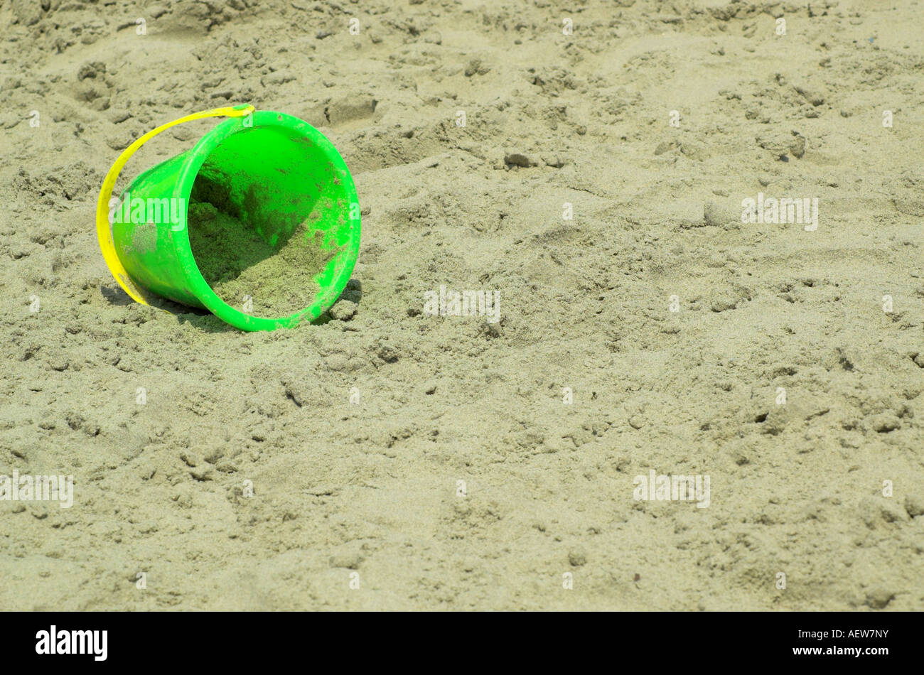 A bright lime green plastic bucket on the sand Stock Photo - Alamy