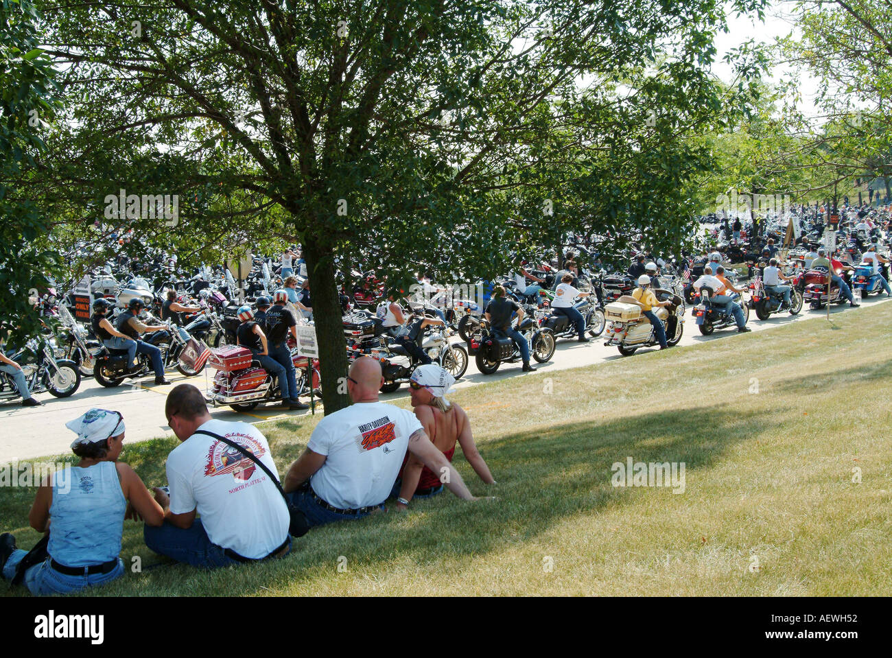 A group of harley riders taking a breather in the shade at the rally ...
