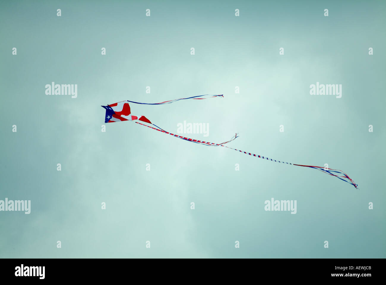 A plane with american flag colors and long tails flying high in sky ...