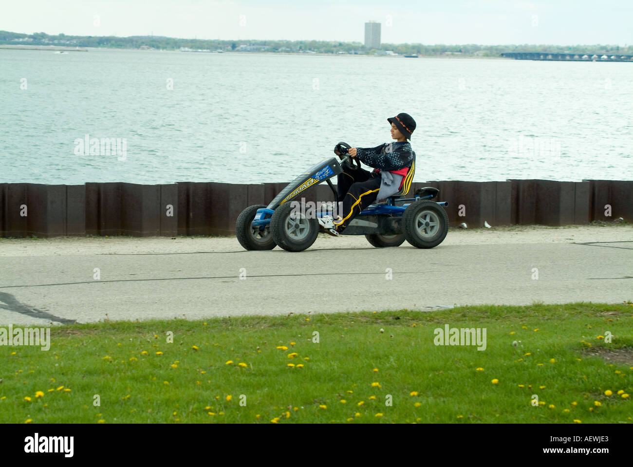 A boy riding his battery powered car on the Michigan lake front of ...