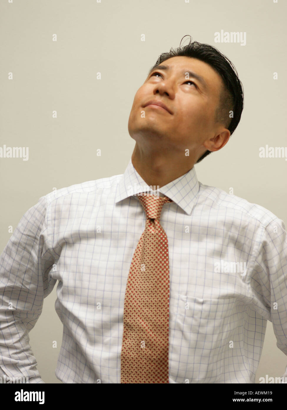 Businessman standing with arms akimbo and looking up Stock Photo - Alamy