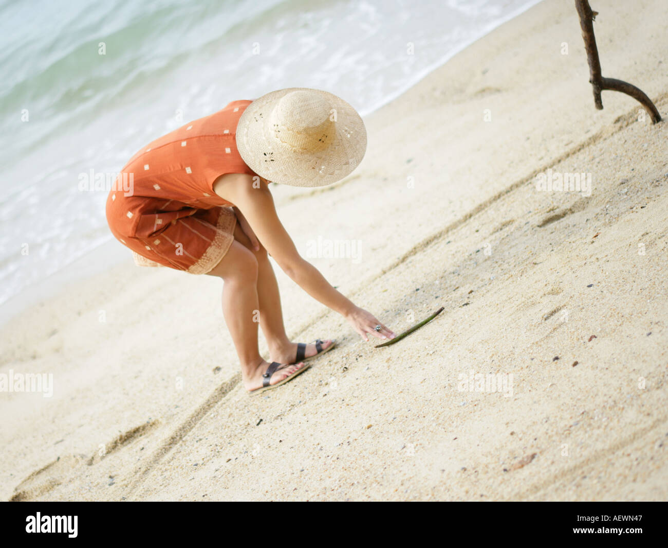 Side profile of a young woman bending on the beach Stock Photo - Alamy