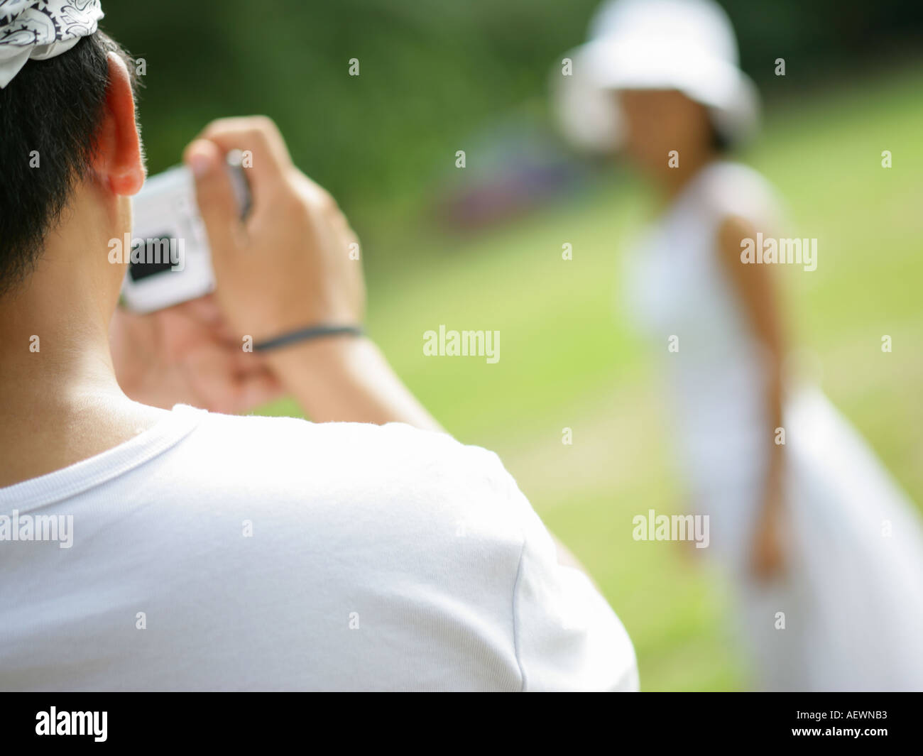 Rear view of a man taking a photograph of a woman Stock Photo - Alamy
