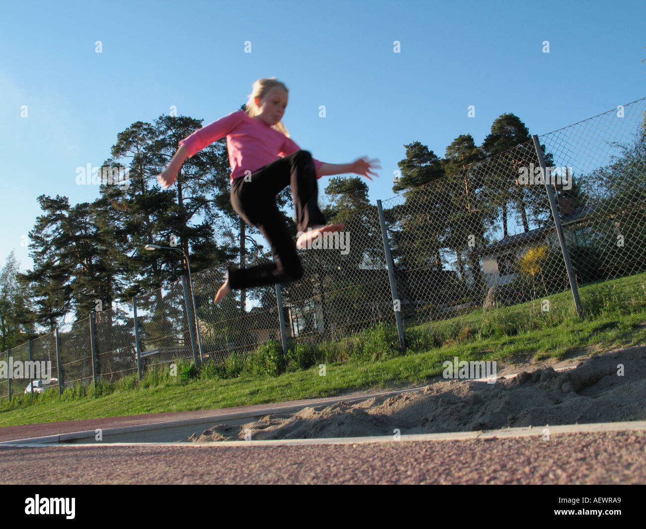 Small girl doing long jump Stock Photo - Alamy