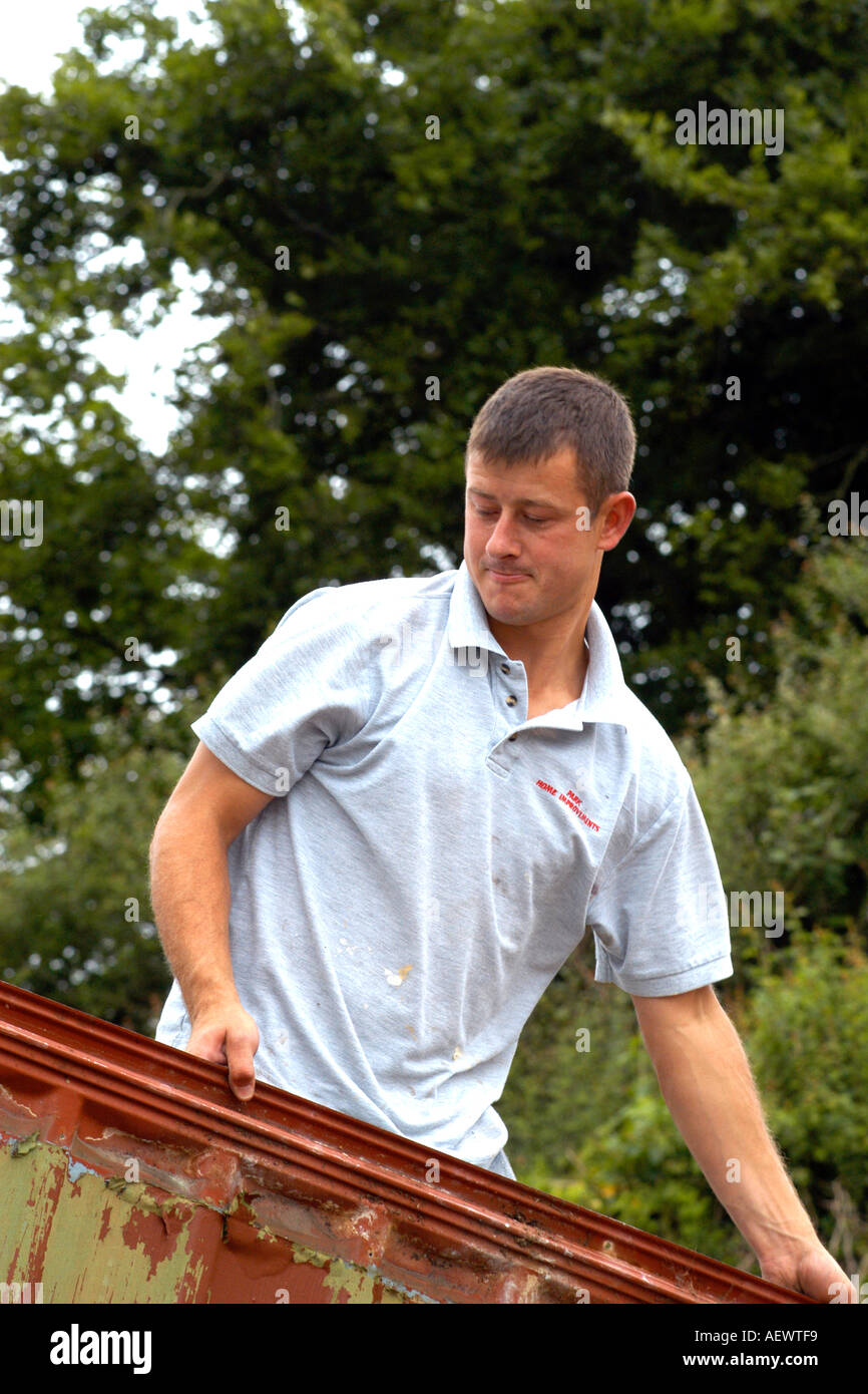 Adult Male Roofing Contractor removing sheeting from a roof Stock Photo ...