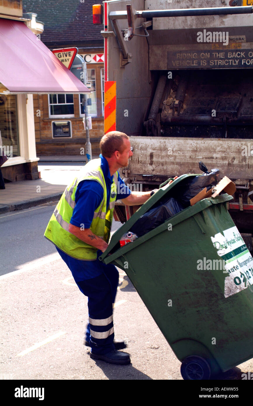 Large commercial bin being wheeled by a bin man on collection day Stock ...