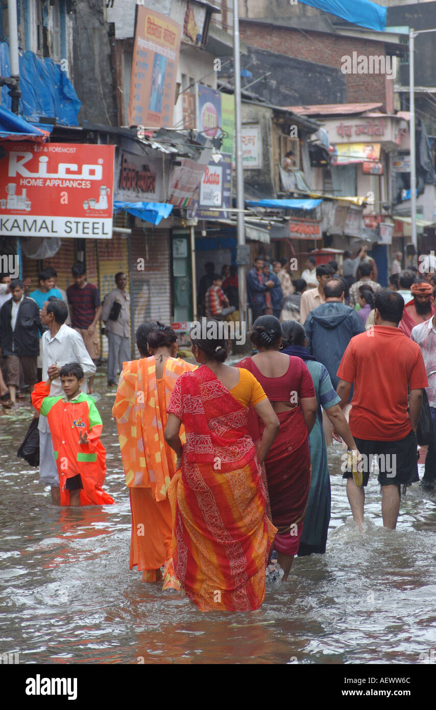 Monsoon rain Indian women wearing sarees walking in flooded street in ...