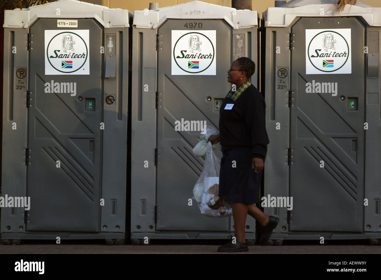 A cleaner walks past mobile toilet cubicles, South Africa Stock Photo ...
