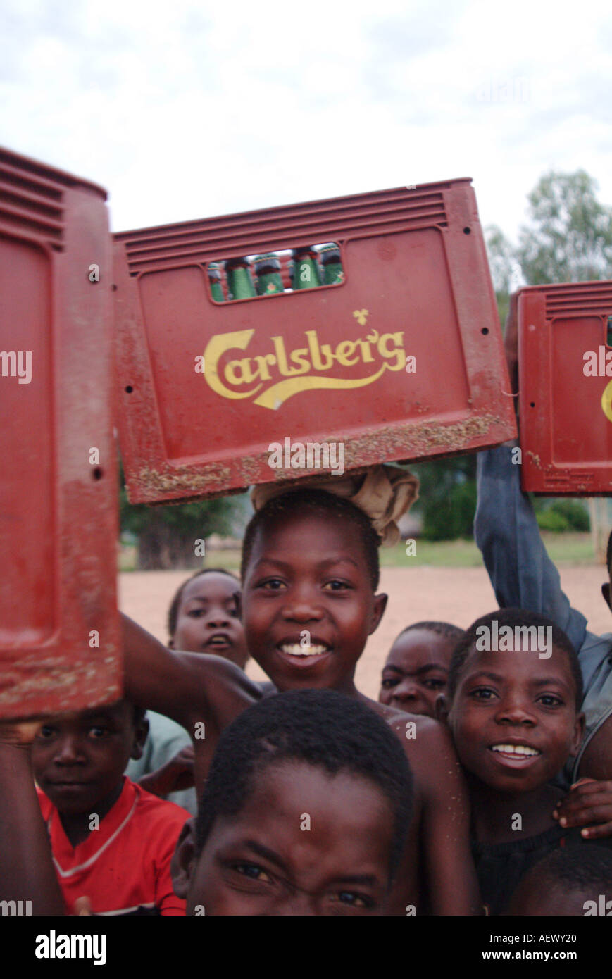 Children carrying crates of Carlsberg beer on their heads in Usisya ...