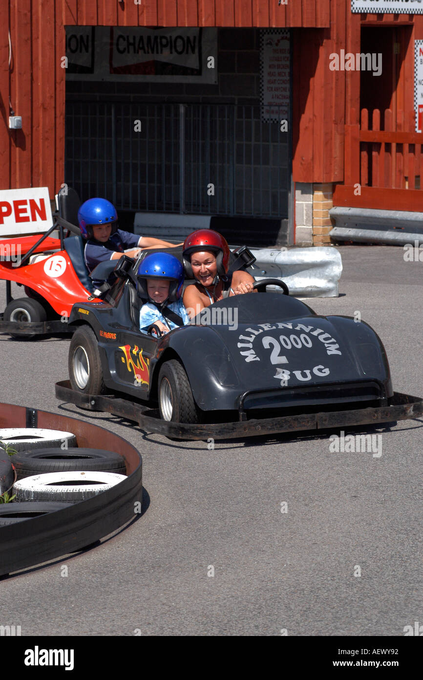 Children having fun driving go-karts around a track at an amusement ...