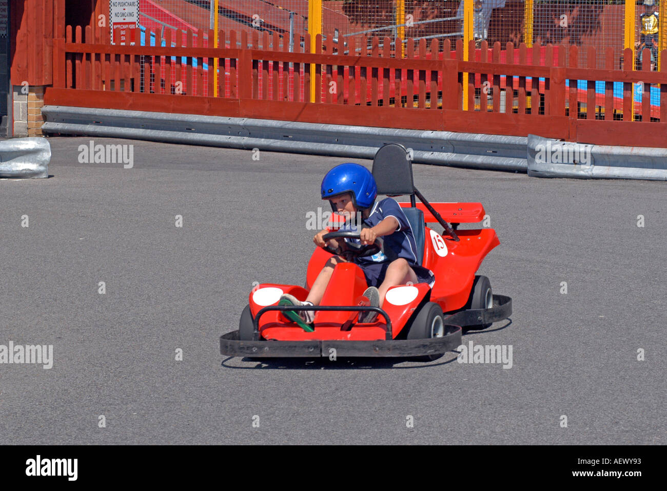 Children having fun driving go-karts around a track at an amusement ...