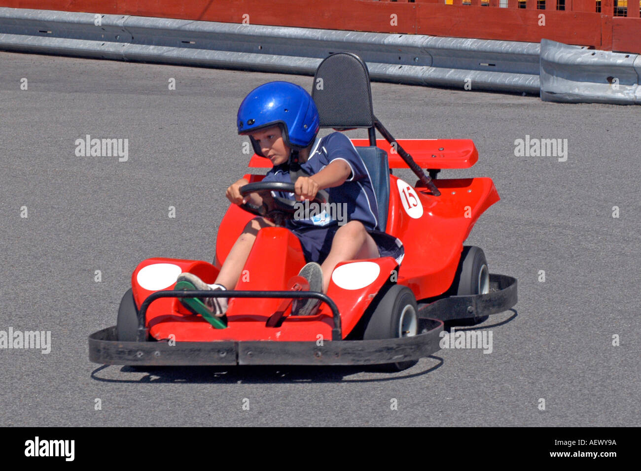 Children having fun driving go-karts around a track at an amusement ...