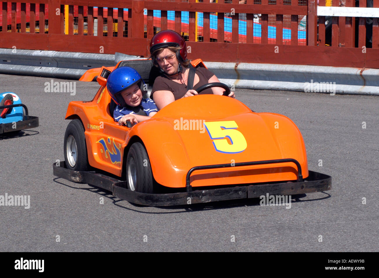 Children having fun driving go-karts around a track at an amusement ...