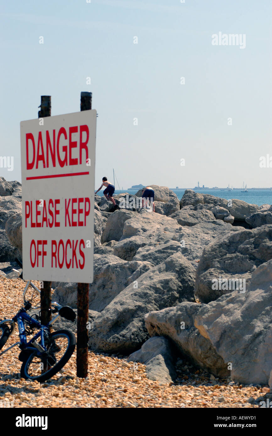 Danger Please keep off rocks sign Stock Photo - Alamy