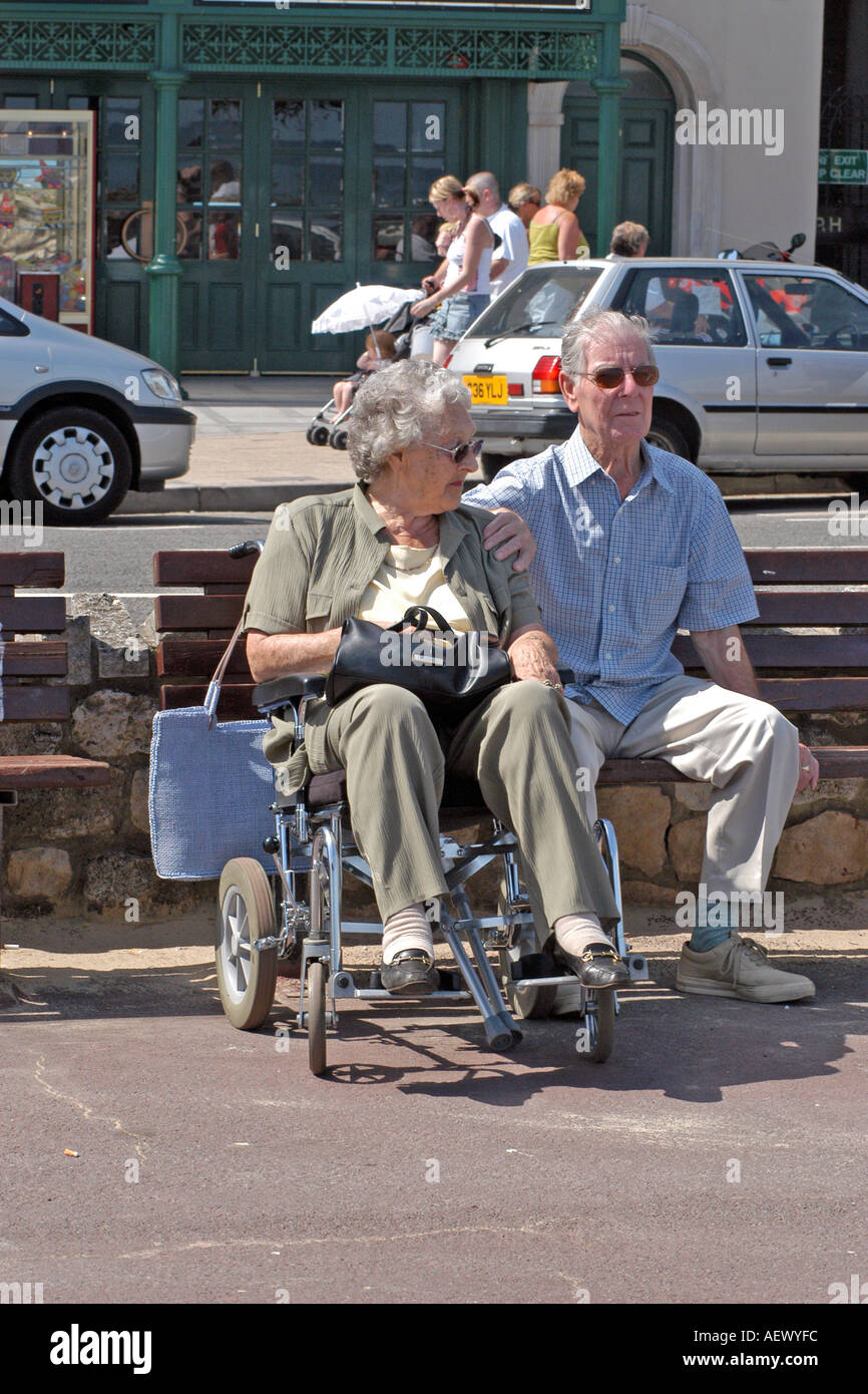 Handicapped senior female in a wheelchair with her husband carer Stock ...