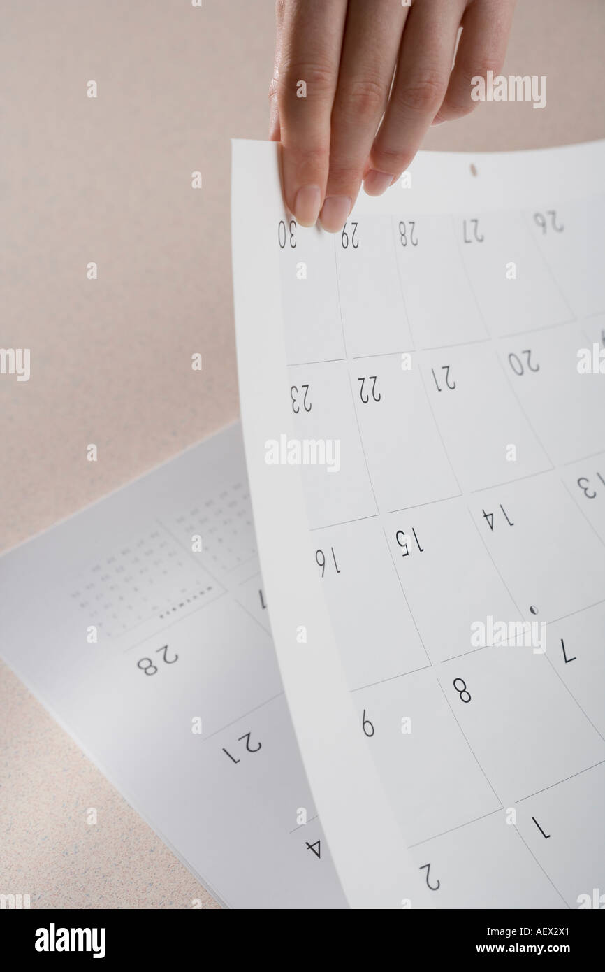 Woman paging through calendar Stock Photo - Alamy