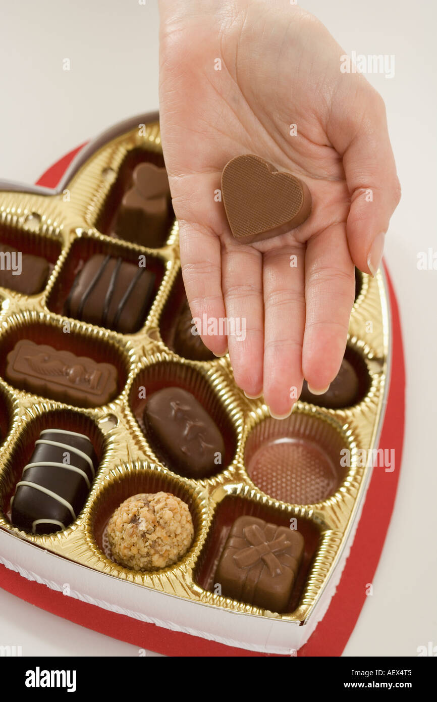 Woman taking a piece of candy from box Stock Photo - Alamy