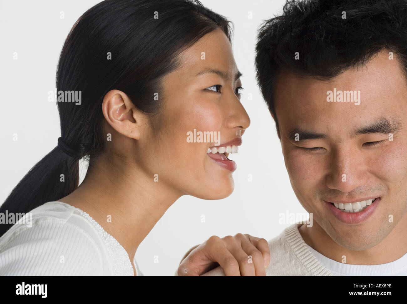 Woman telling man a secret Stock Photo - Alamy