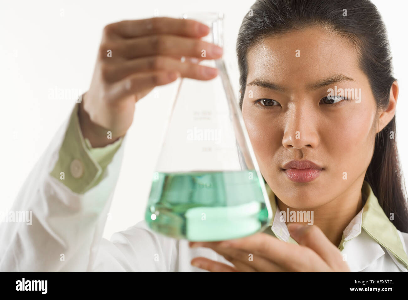 Scientist looking at glass beaker Stock Photo - Alamy