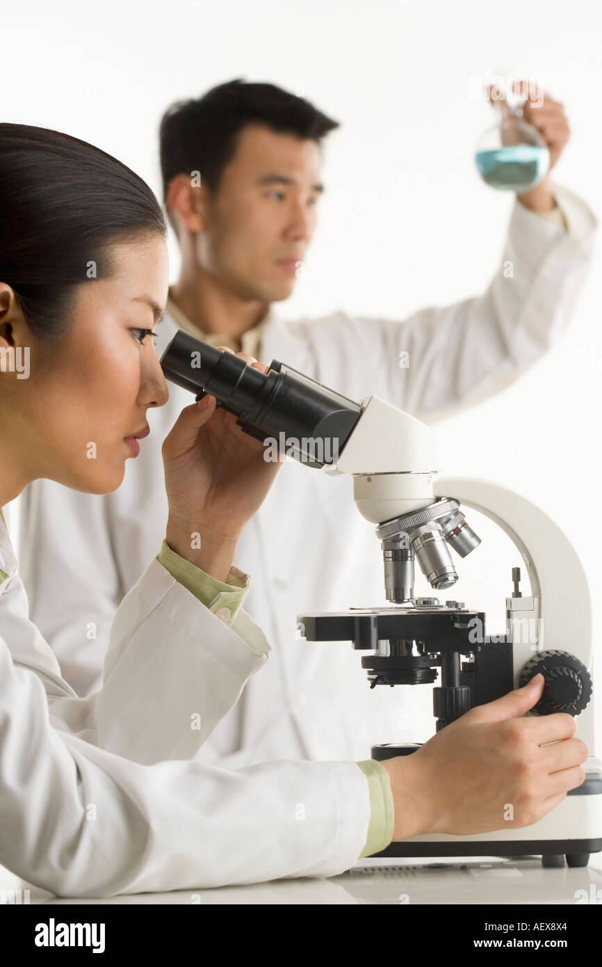 Scientists with beaker and microscope Stock Photo - Alamy