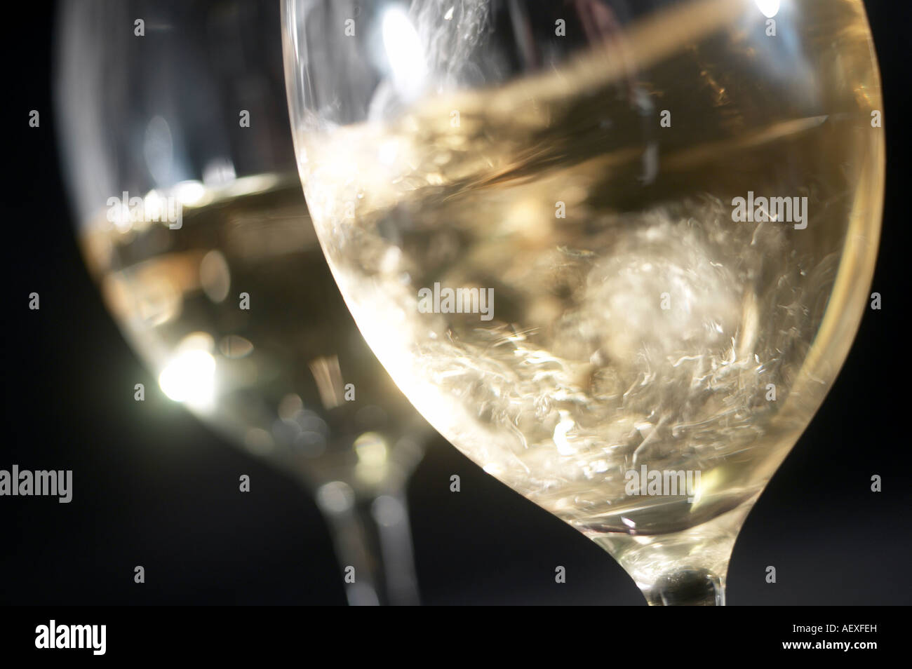 WHITE WINE IN GLASSES ON A DARK, BLACK BACKGROUND Stock Photo - Alamy