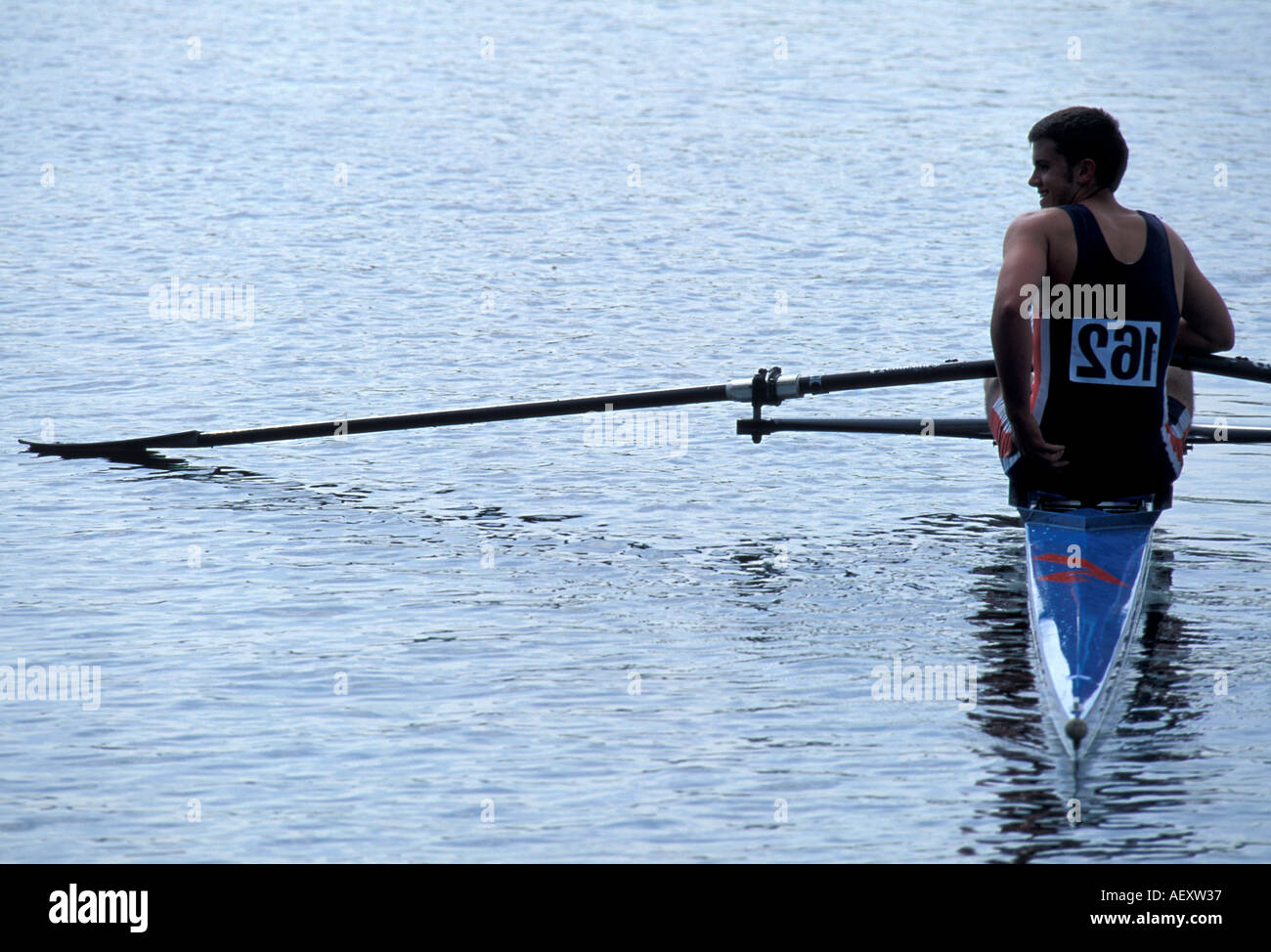 Landscape format image of a single male rower in a boat with oar ...