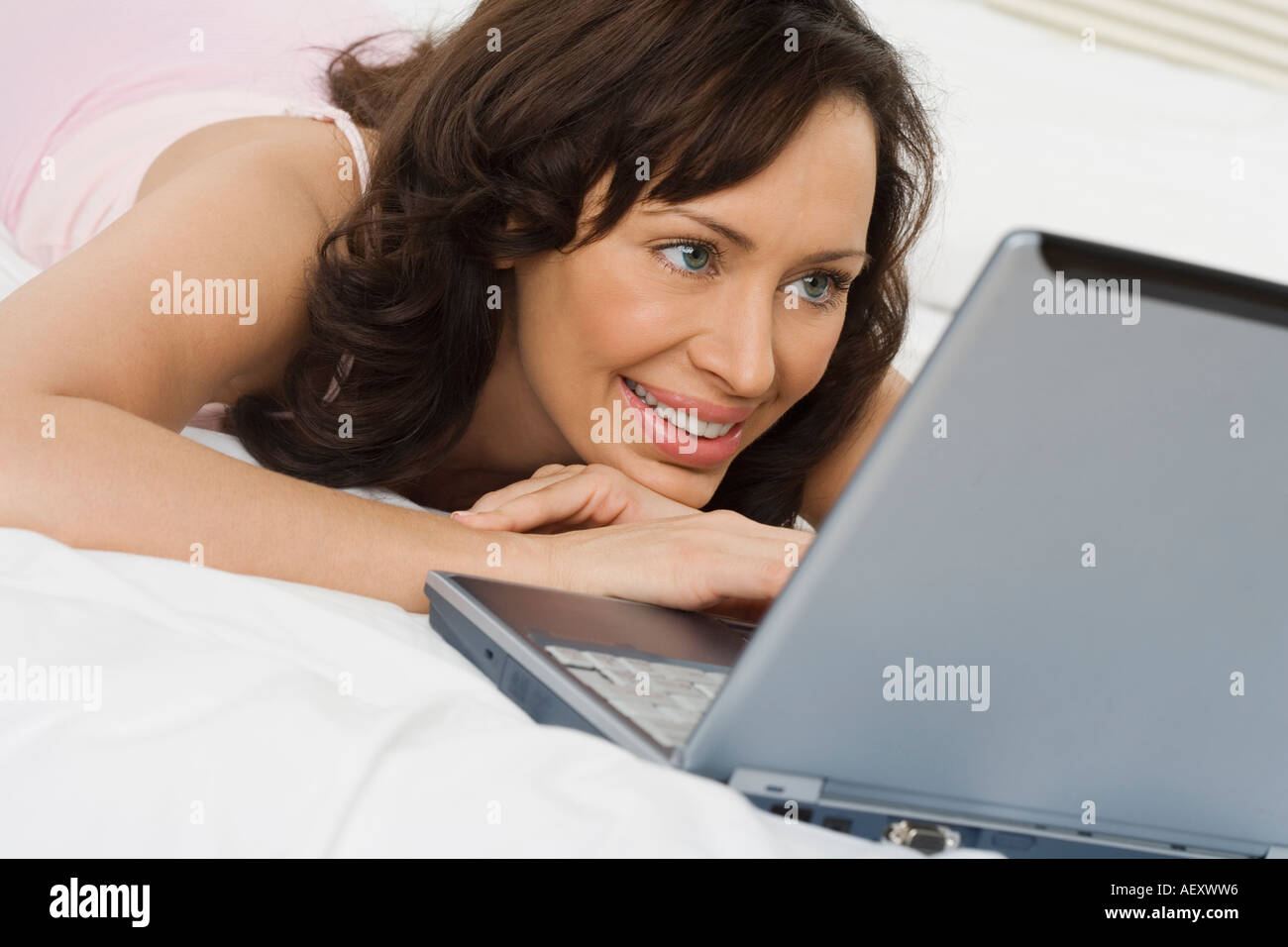 Woman in bed with laptop computer Stock Photo - Alamy