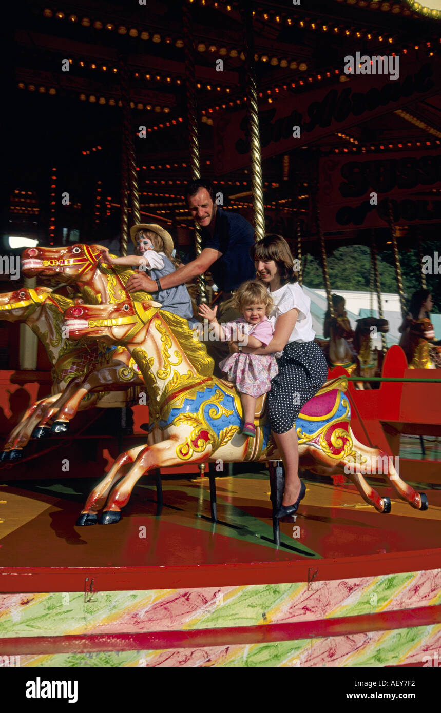 Parents and their children riding on a carousel Stock Photo - Alamy