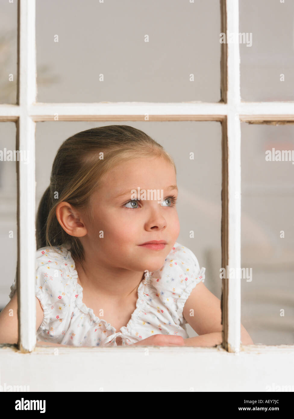 Young girl looking out window Stock Photo - Alamy