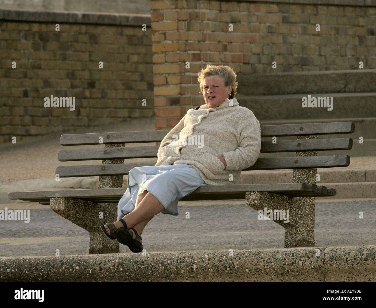 Woman sitting on bench Stock Photo - Alamy