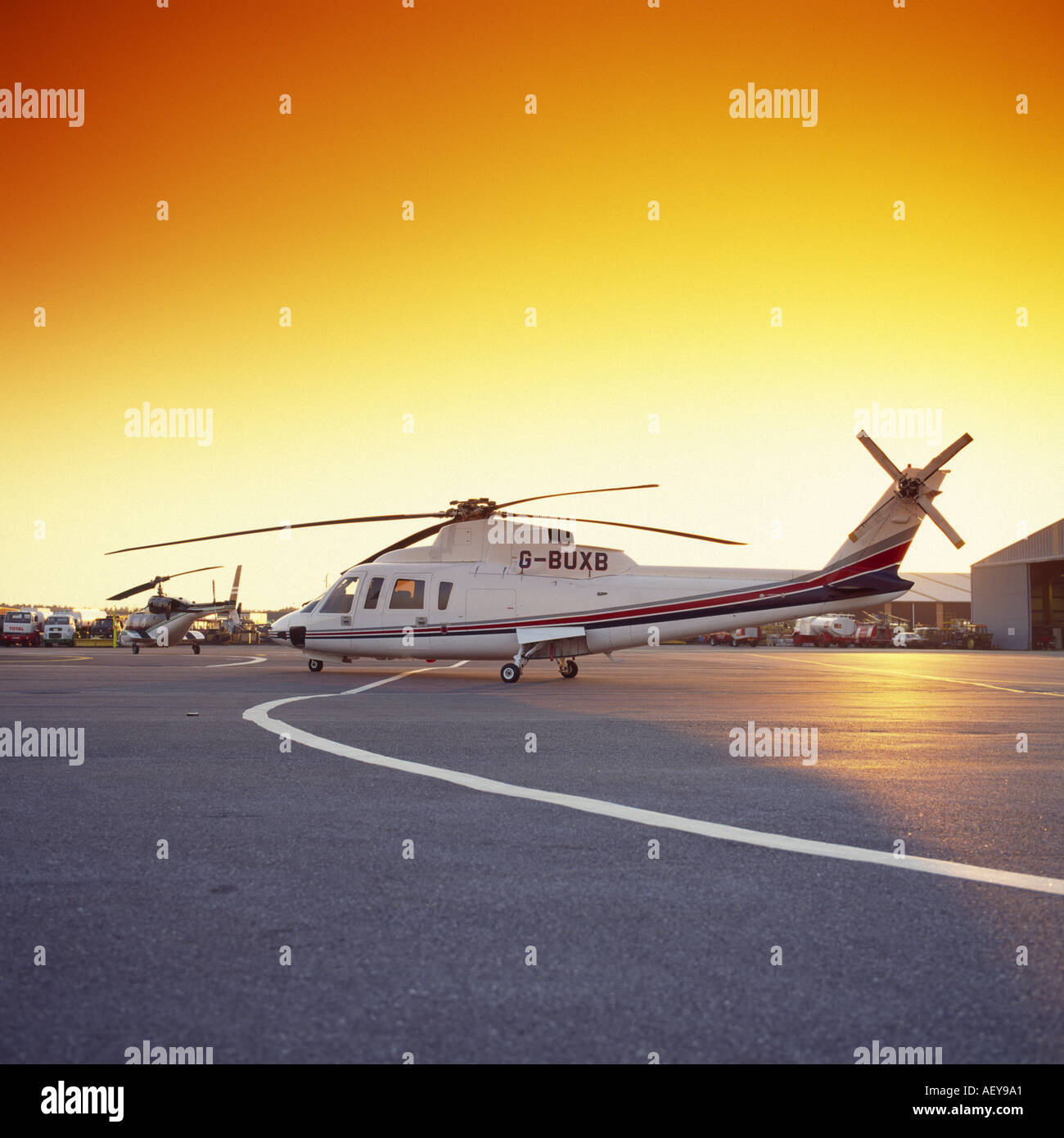 Helicopter on apron with sunset sky Stock Photo - Alamy
