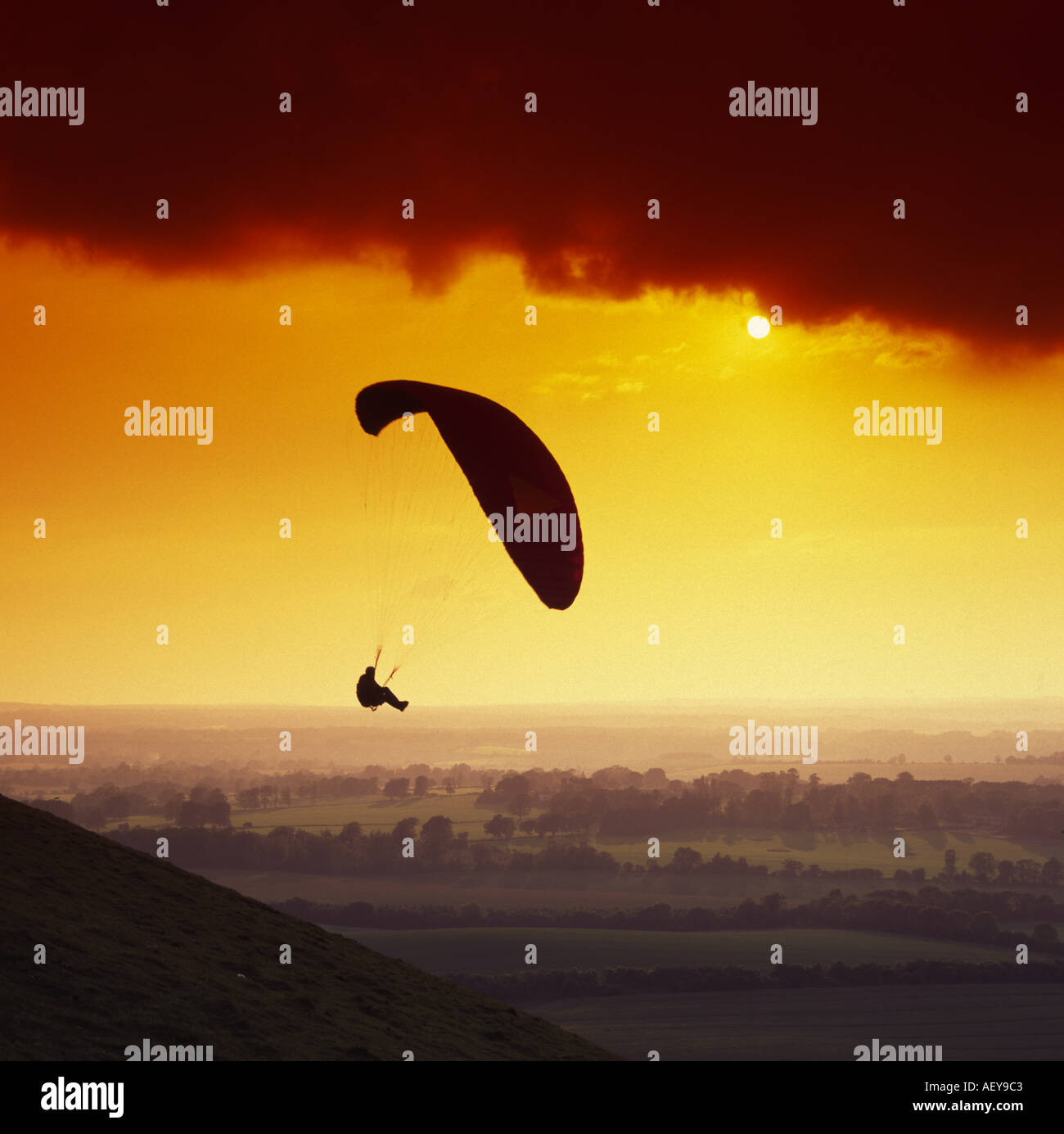 Paraglider flying against sunset Stock Photo - Alamy