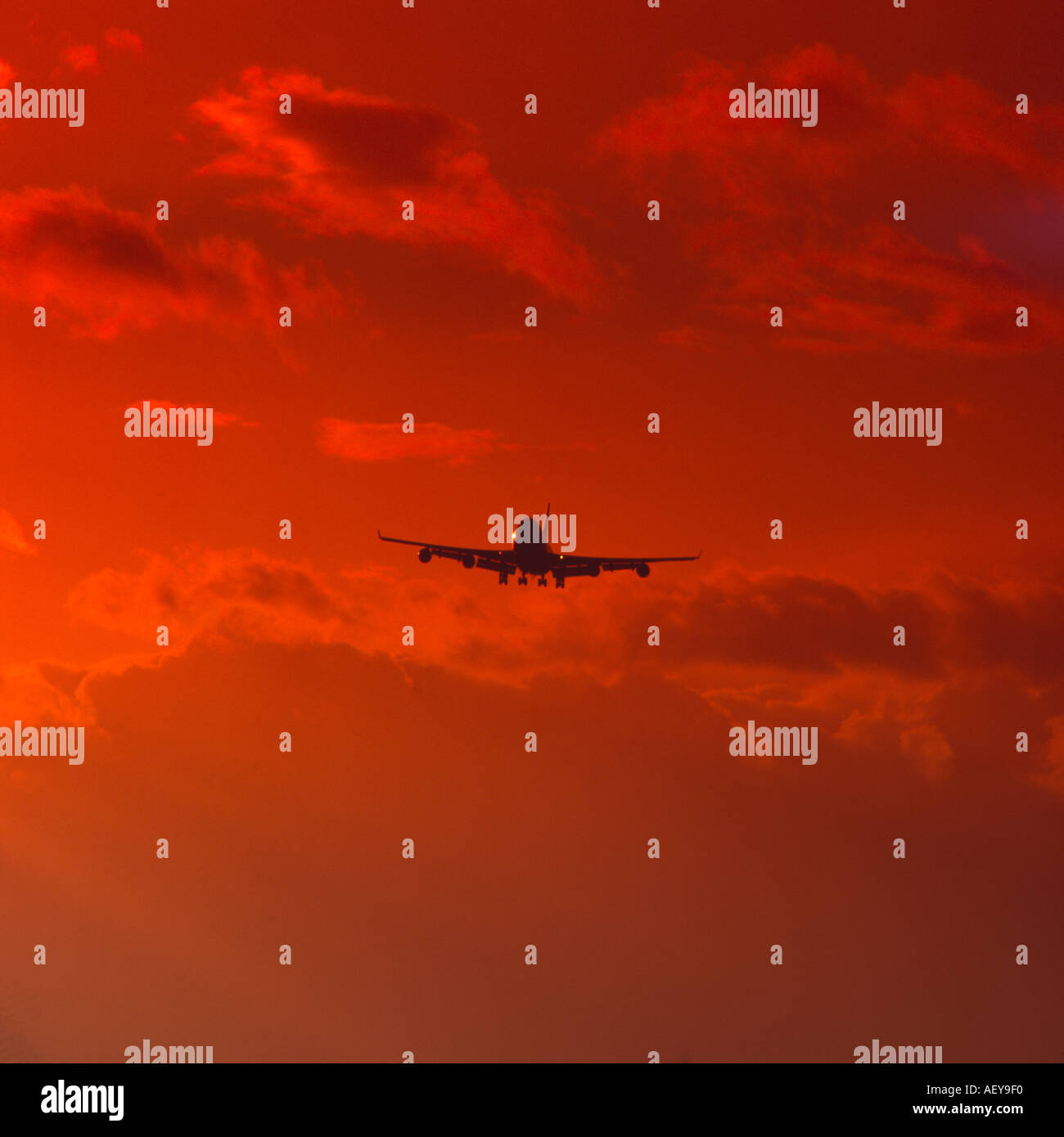 Jet airliner landing against dramatic red sky Stock Photo - Alamy