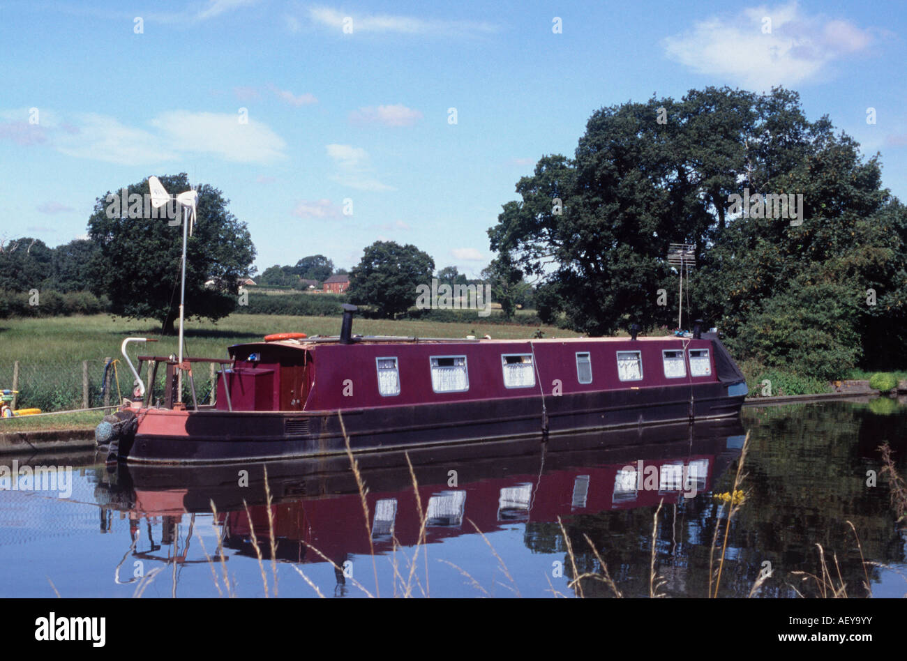 Liveaboard narrowboat with wind generator and TV mast on a residential ...