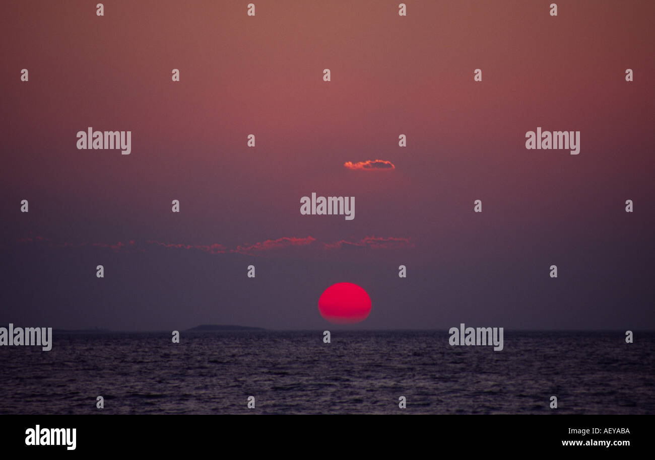 Pink sun setting on the horizon of the sea Stock Photo - Alamy