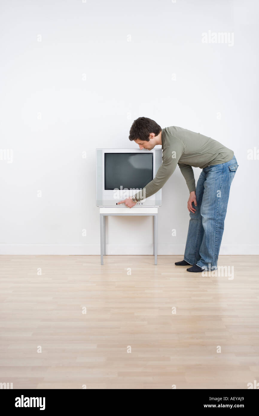 Man turning on television Stock Photo - Alamy