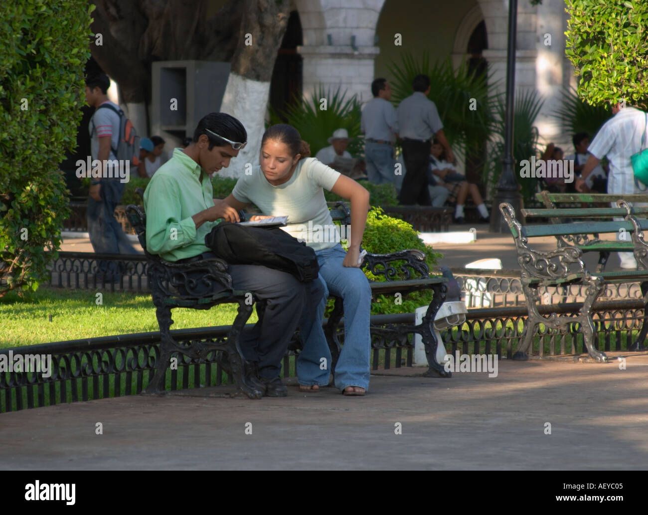 Couple sitting on bench in town square in Merida Mexico Stock Photo - Alamy