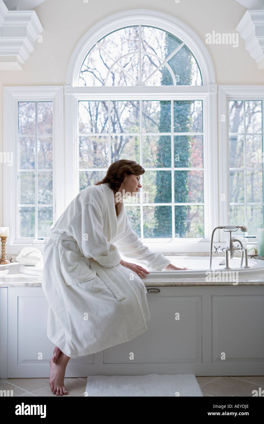 Woman in robe drawing bath Stock Photo - Alamy