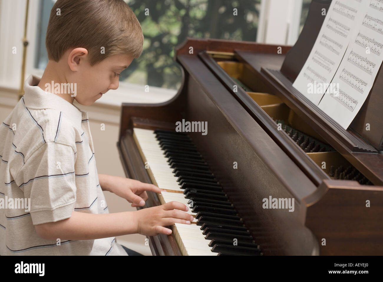 Young boy playing piano Stock Photo - Alamy