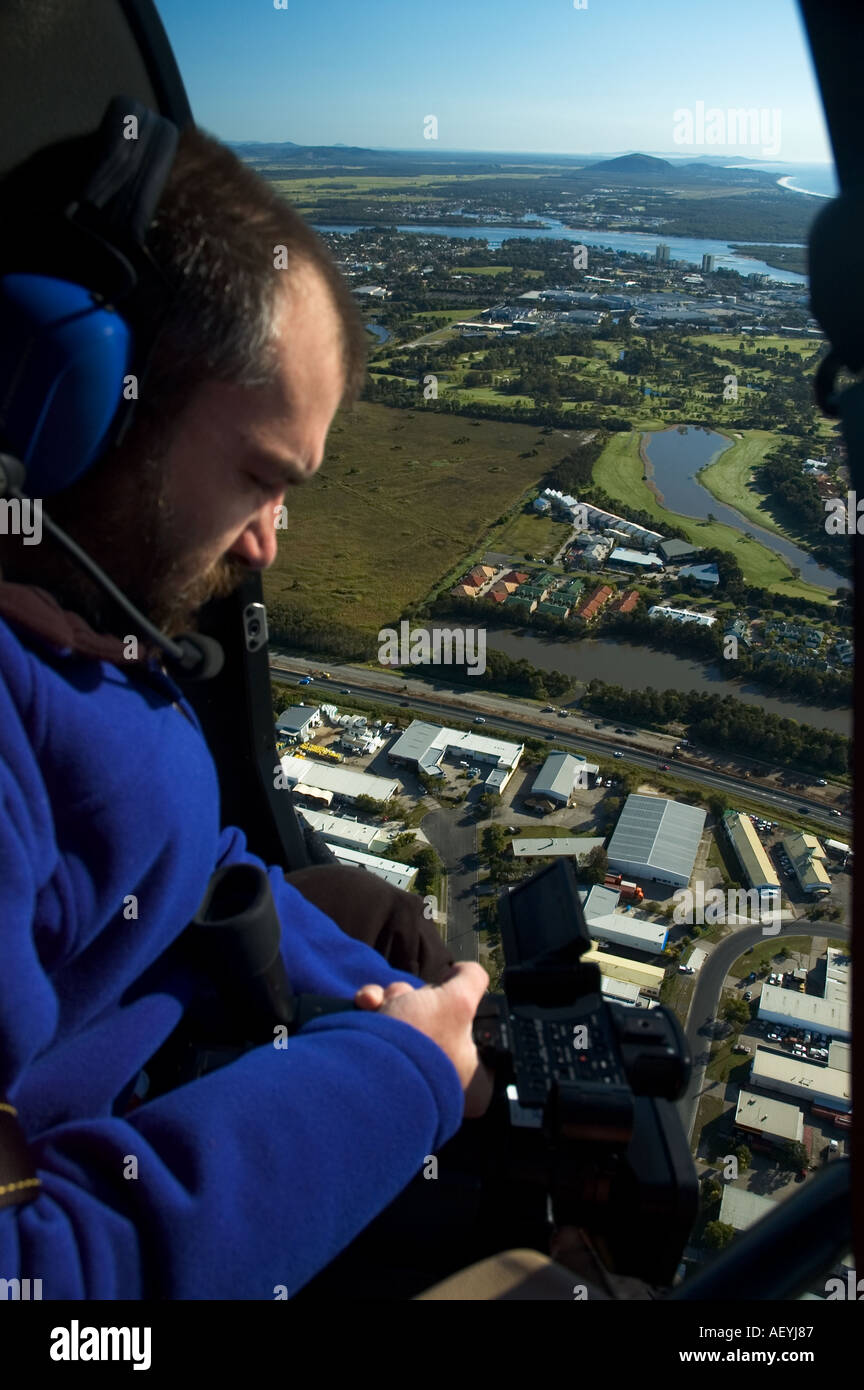Cameraman filming from open cockpit of small chopper Stock Photo - Alamy