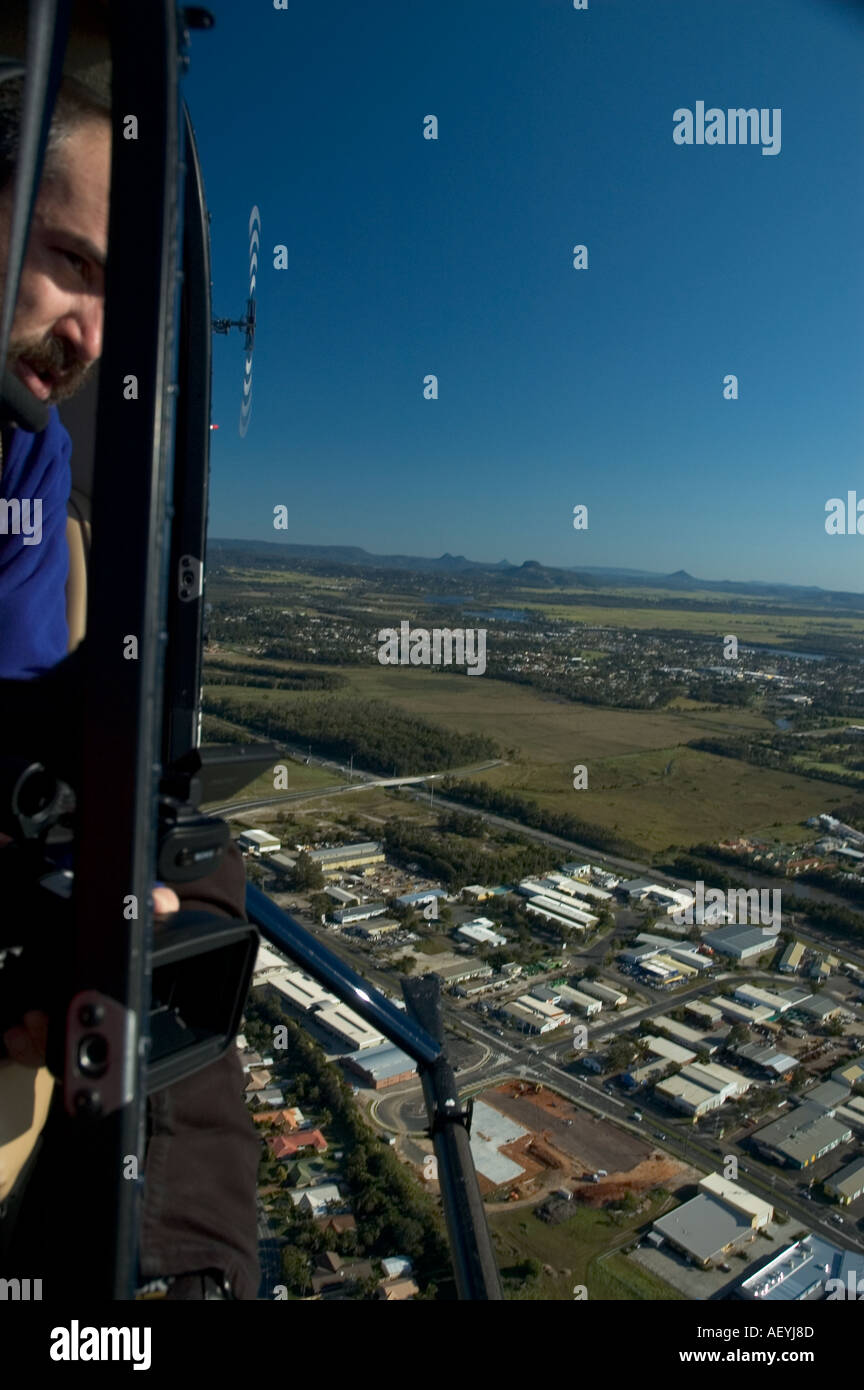 Cameraman filming from open cockpit of small chopper Stock Photo - Alamy