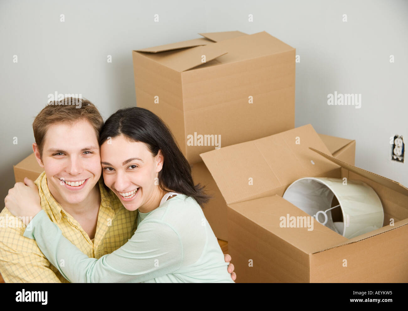 Couple hugging next to boxes in new house Stock Photo - Alamy